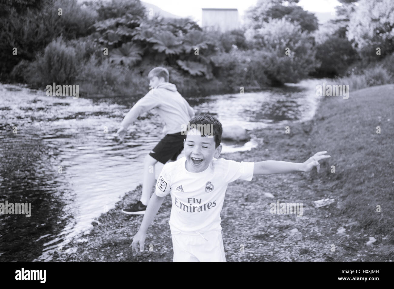 Boys playing by river Stock Photo - Alamy