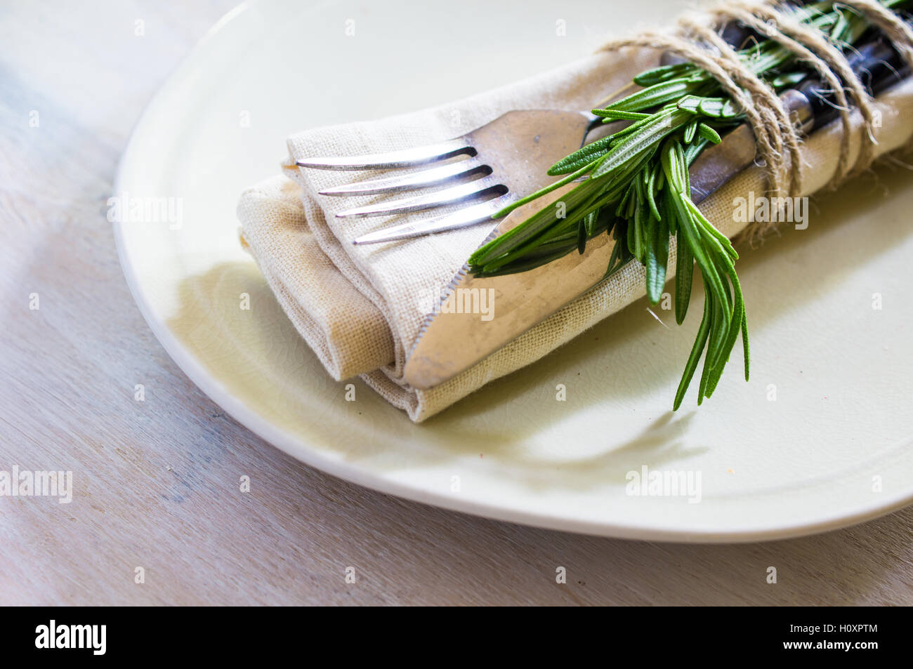 Summertime table setting with fresh rosemary on rustic wooden table ...