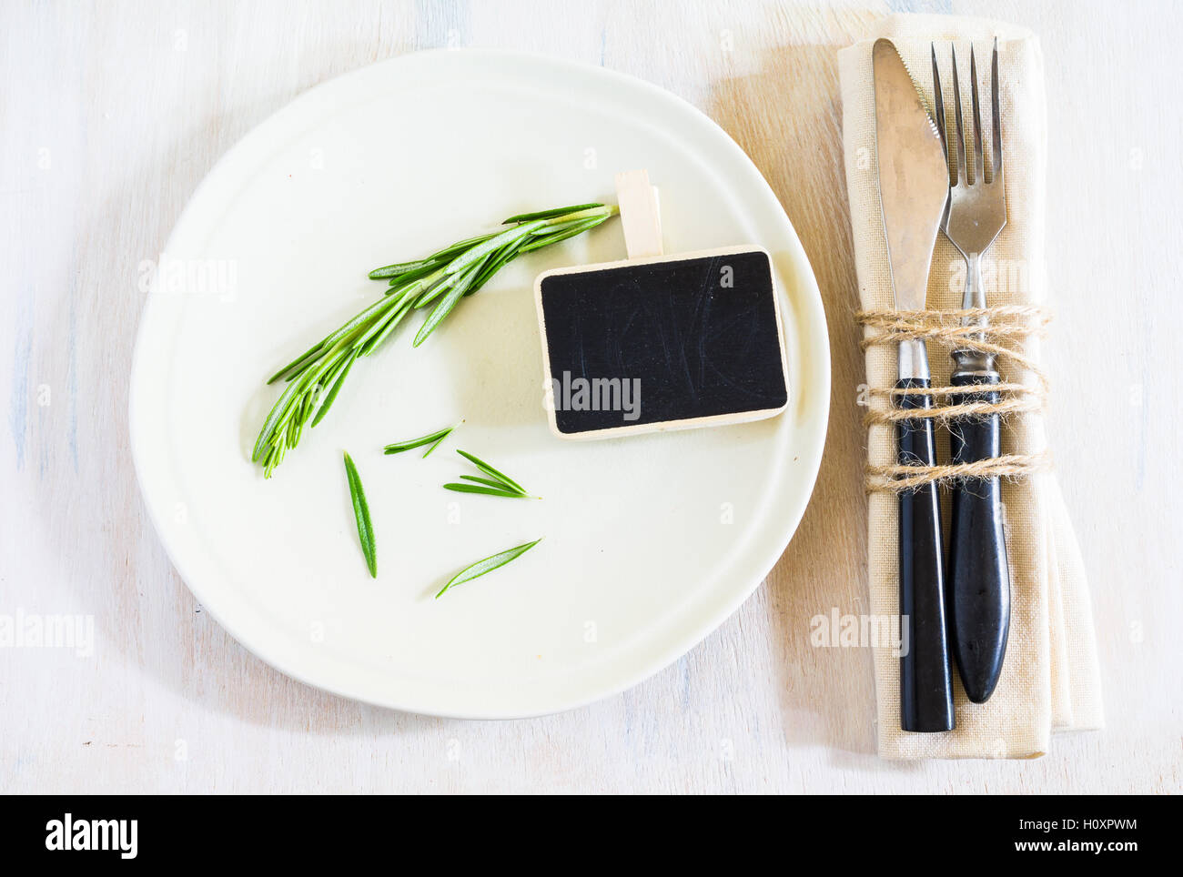 Summertime table setting with fresh rosemary on rustic wooden table ...