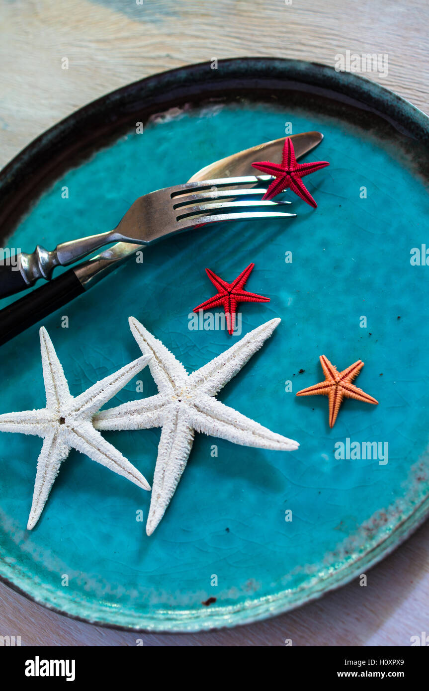 Marine table setting with sea stars and vintage tableware on rustic ...