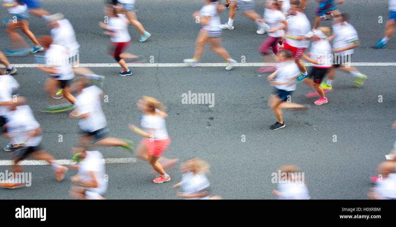 People in white T-shirts running semi marathon on city streets in ...