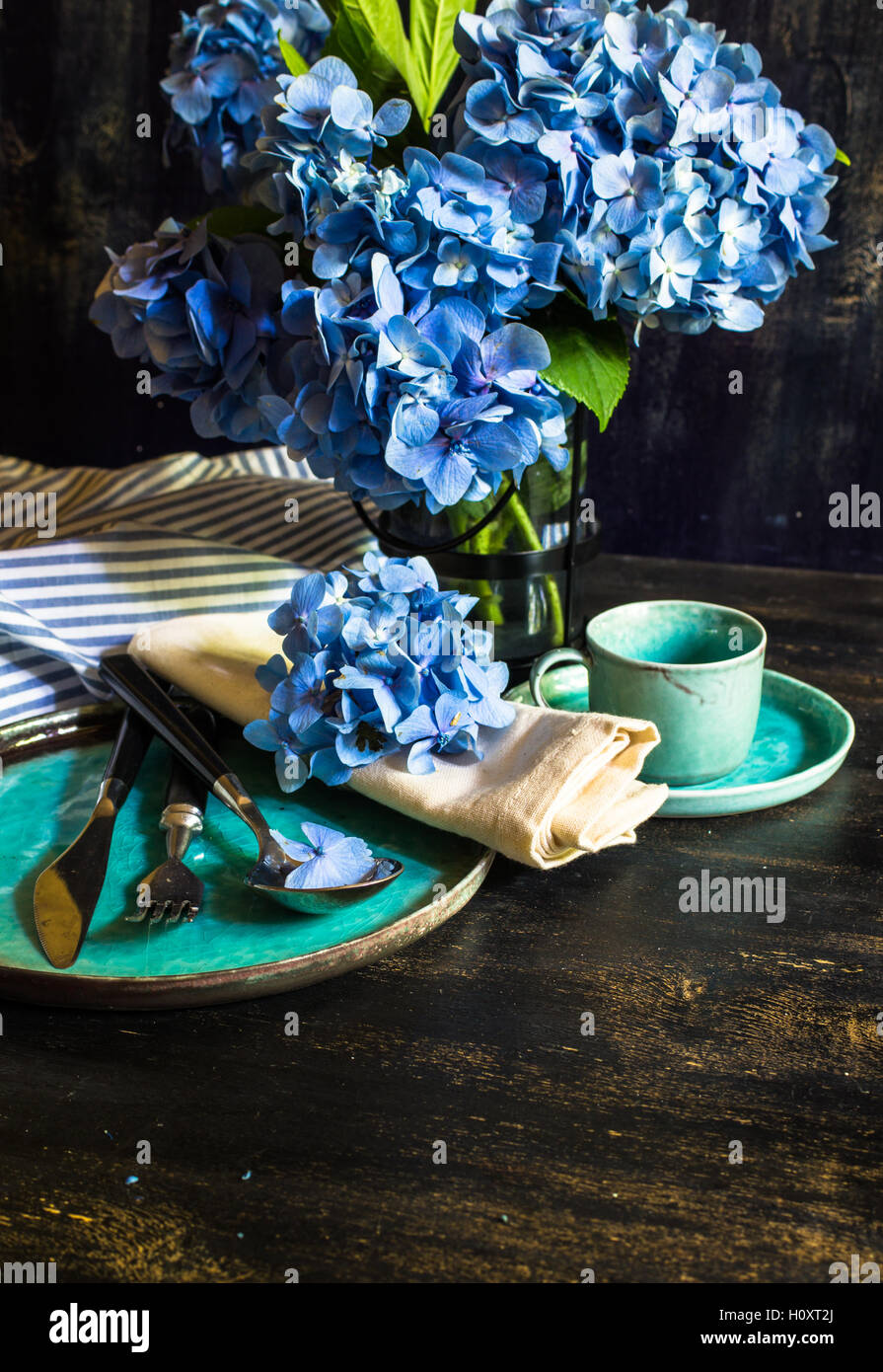 Vintage style table setting with fresh blue hydrangea flowers on rustic ...