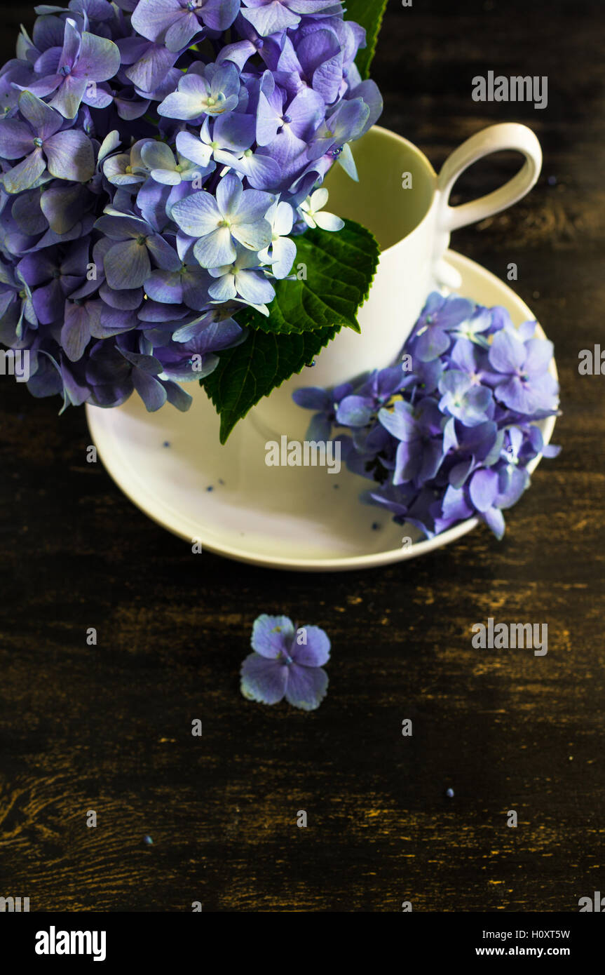 Vintage style table setting with fresh blue hydrangea flowers on rustic ...
