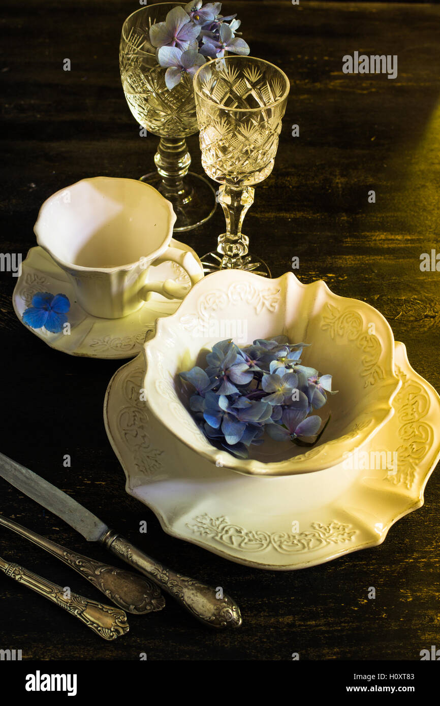 Vintage style table setting with fresh blue hydrangea flowers on rustic ...