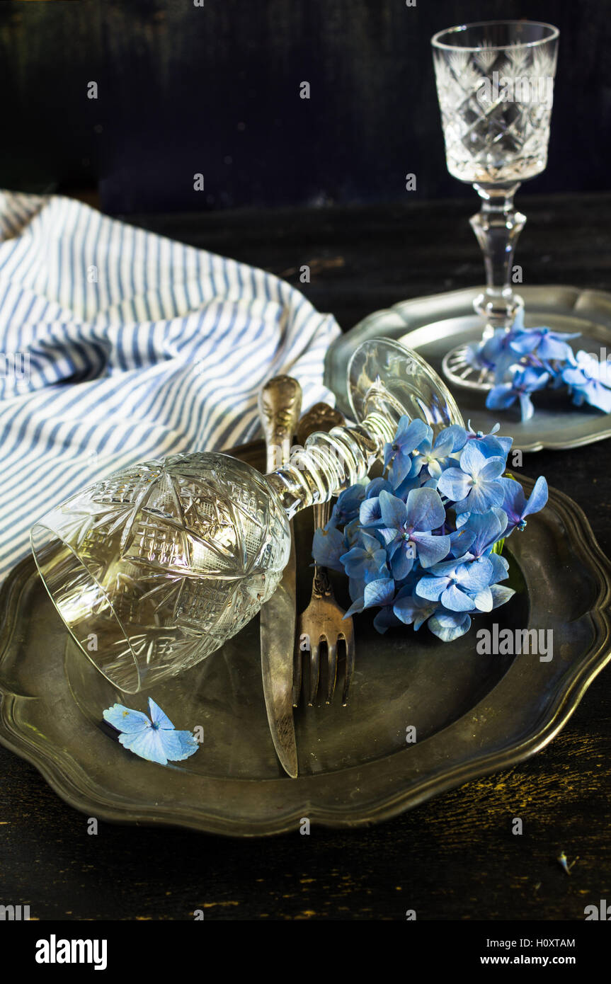 Vintage style table setting with fresh blue hydrangea flowers on rustic ...