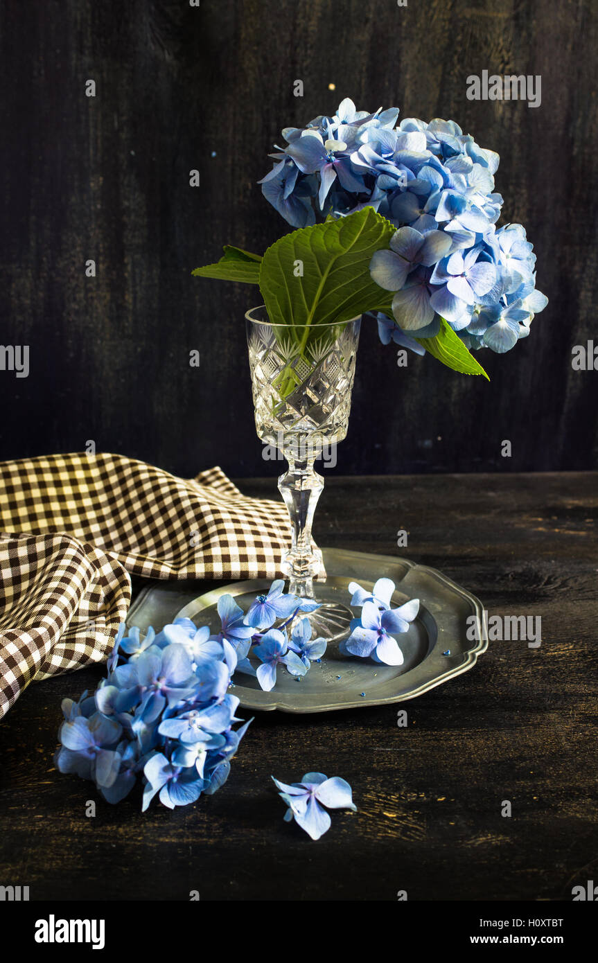 Vintage style table setting with fresh blue hydrangea flowers on rustic ...