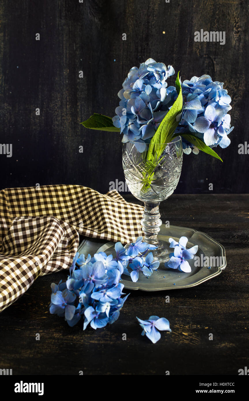 Vintage style table setting with fresh blue hydrangea flowers on rustic ...