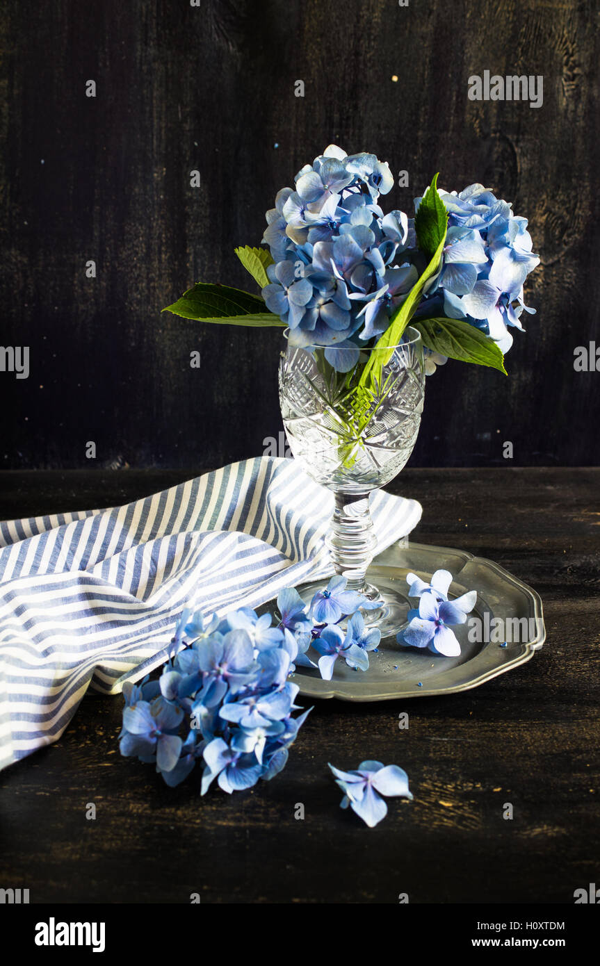 Vintage style table setting with fresh blue hydrangea flowers on rustic ...