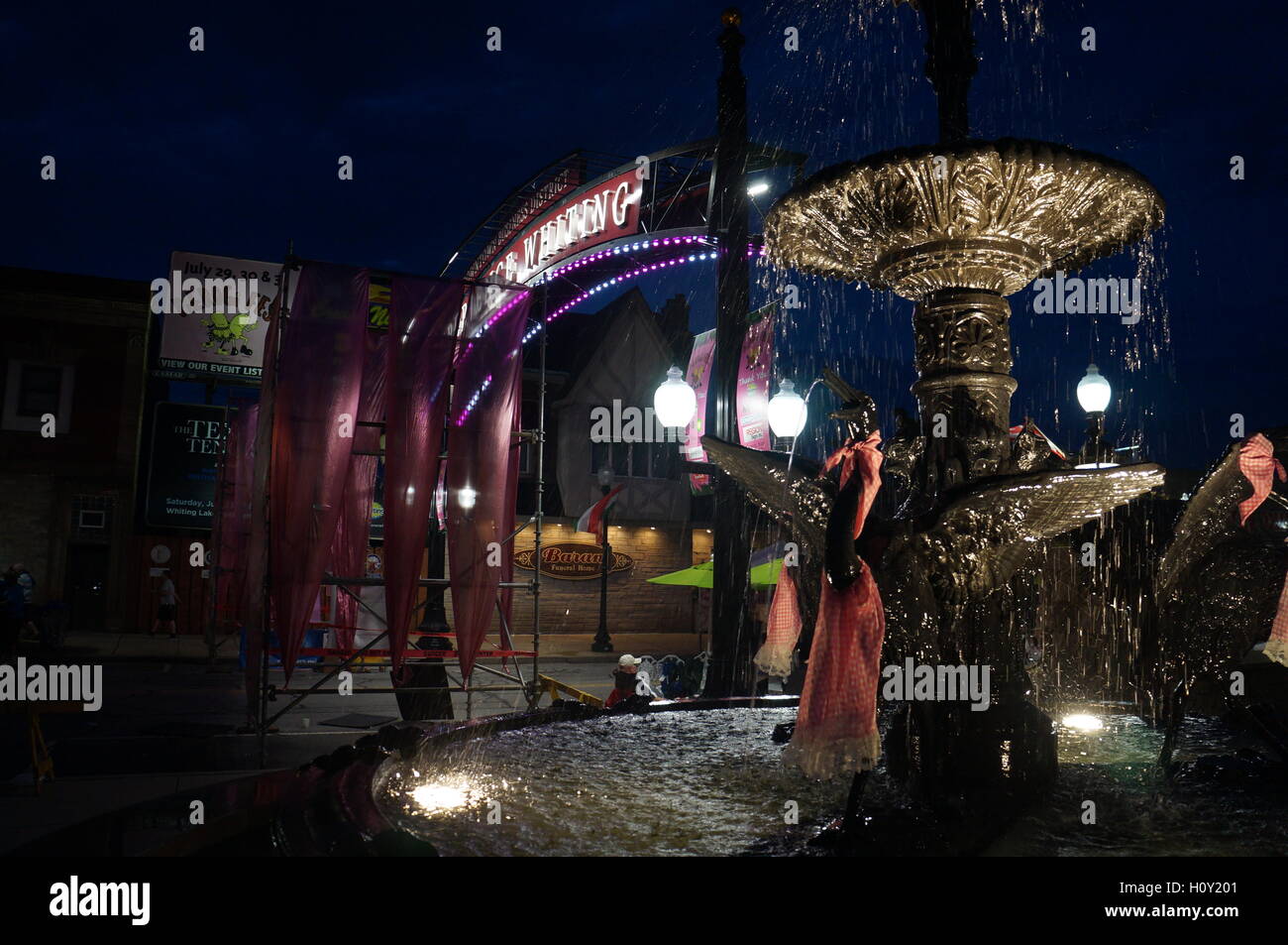 night time view of decorative fountain and welcome sign arch for ...