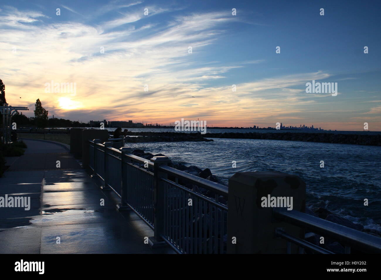 Sunset through clouds over water-soaked lakeview beach at Whiting ...