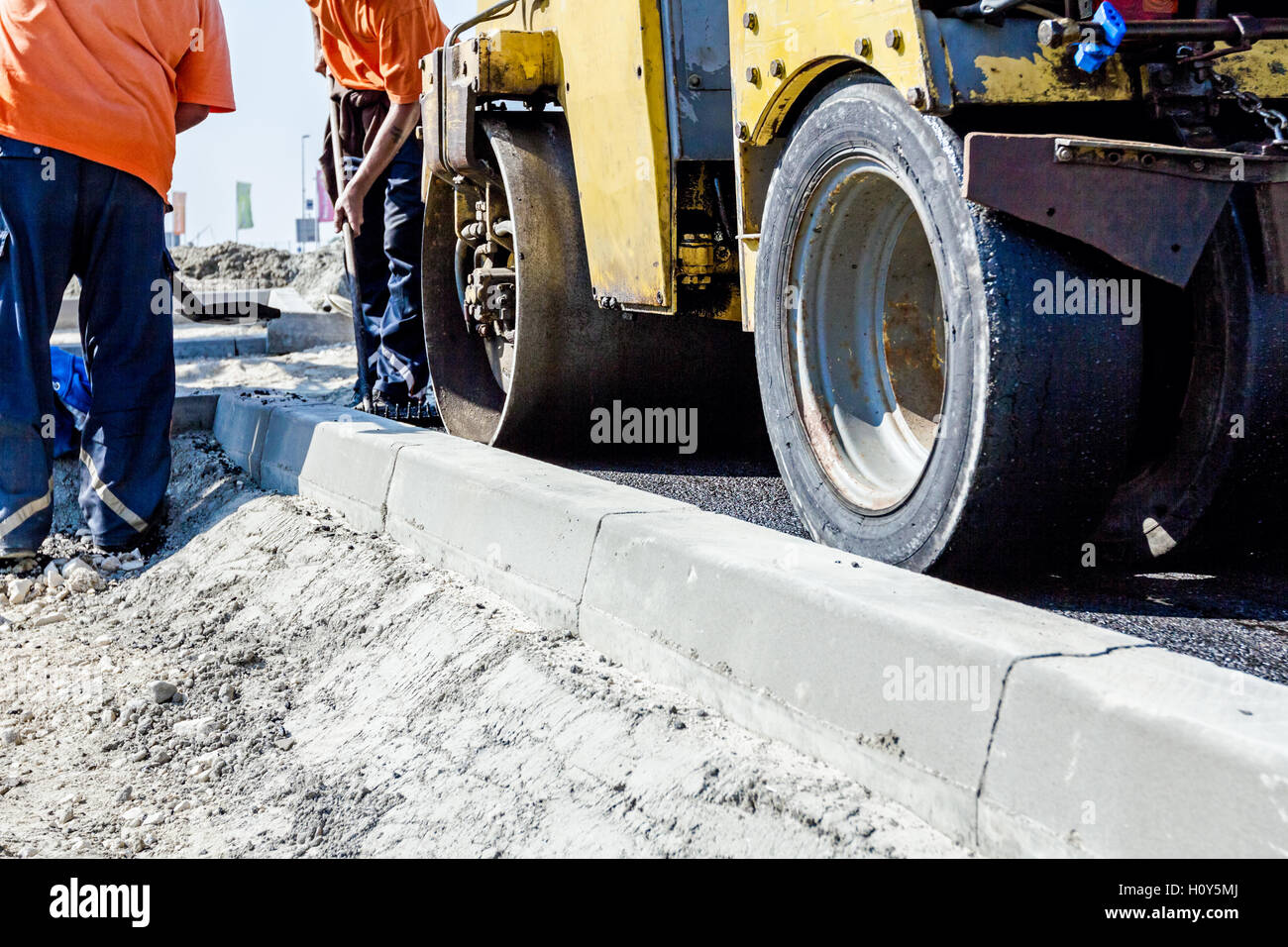 Small steamroller is flatting new road made of asphalt. Detail on newly ...