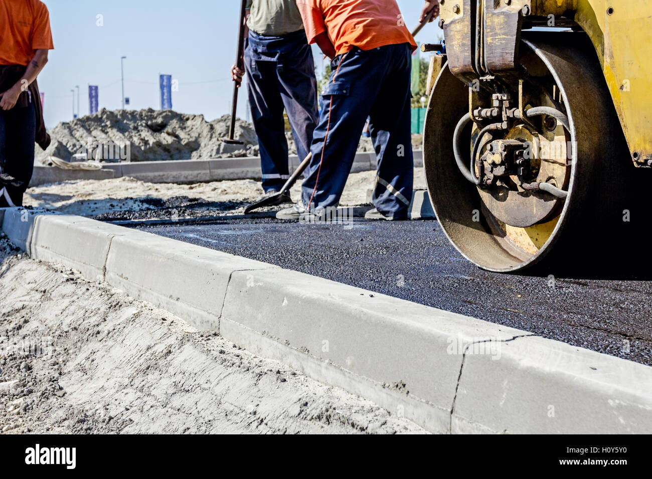 Small steamroller is flatting new road made of asphalt. Detail on newly ...