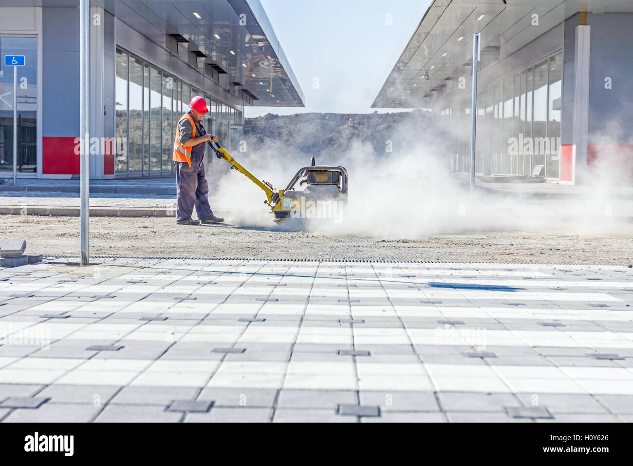 Worker is working with vibration plate compactor machine before ...