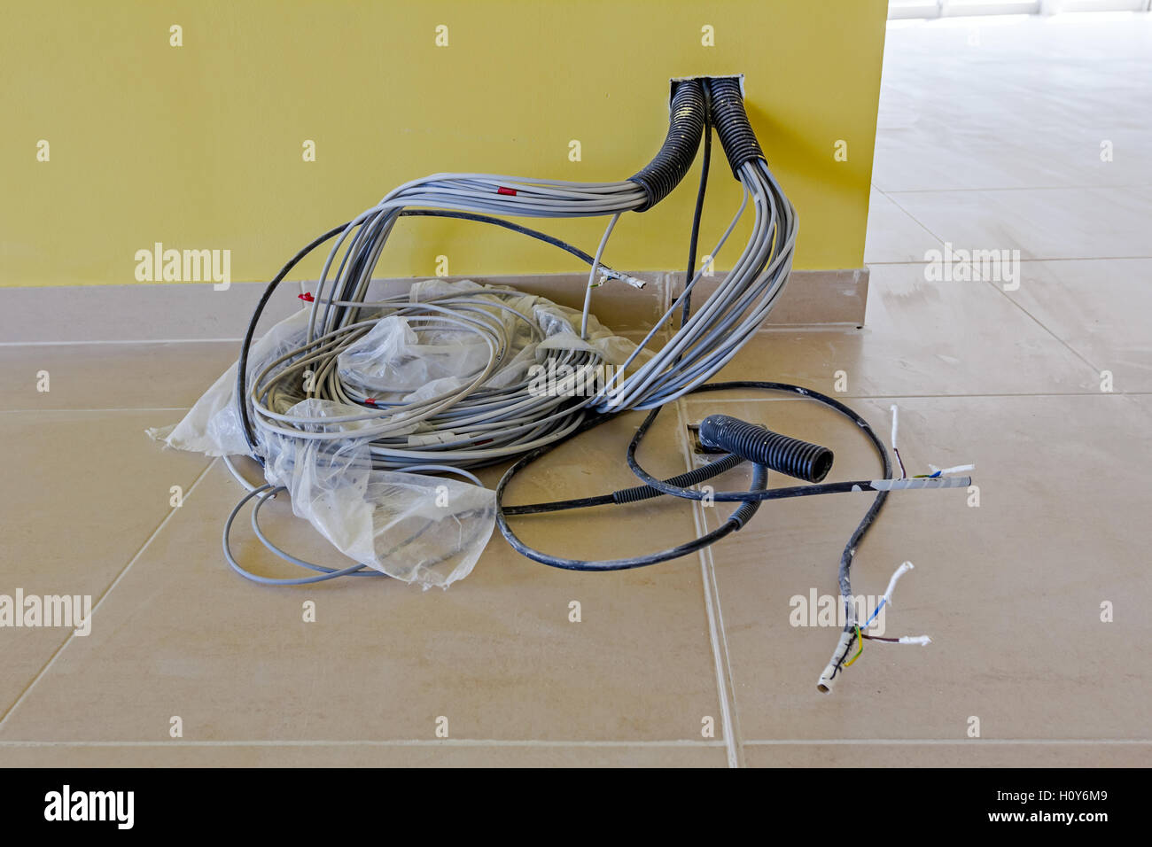 Bunch of various electric cables in corrugated pipe is coming out from ...