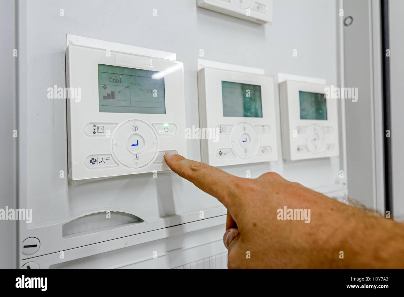 Hand is pushing button, operating to climate control panel which ...