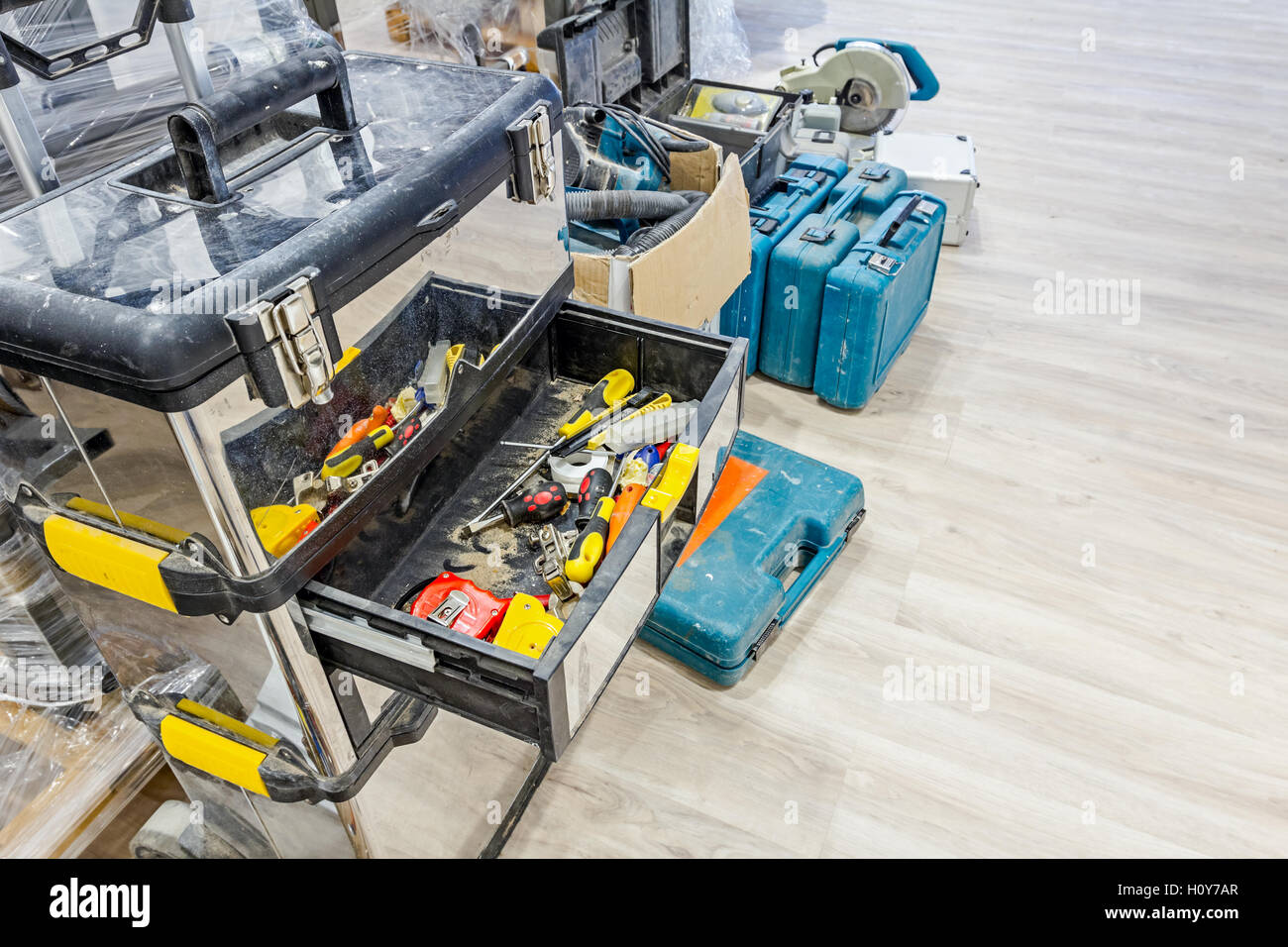 Variety of carpentry tools in tool box with open drawer on wooden floor ...