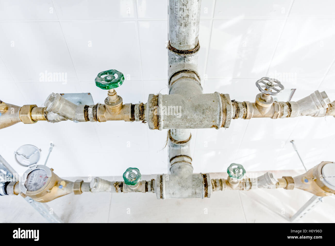 Water meters and valves in measuring place, tiled room with white tiles ...