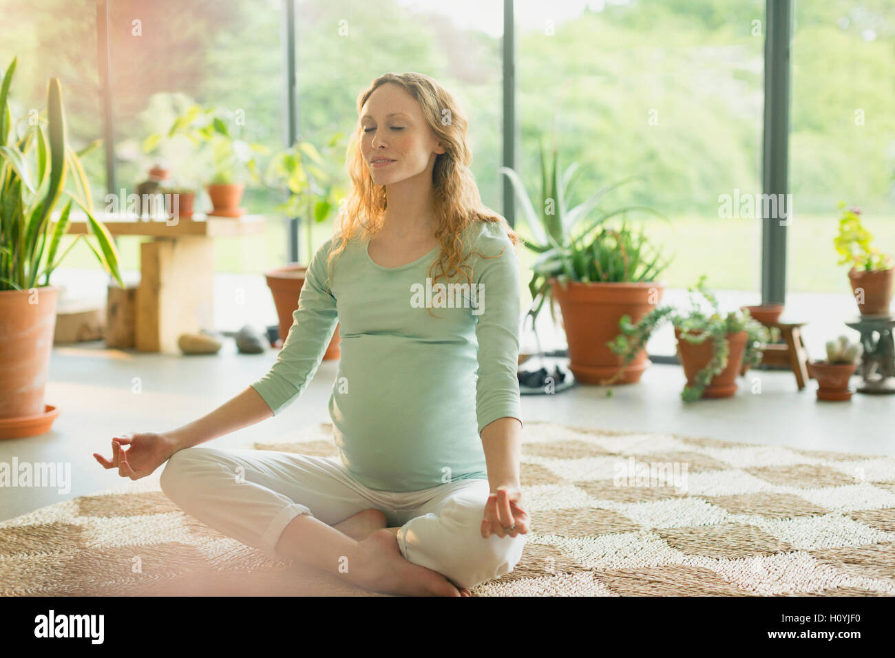 pregnancy woman meditating lotus position Stock Photo - Alamy