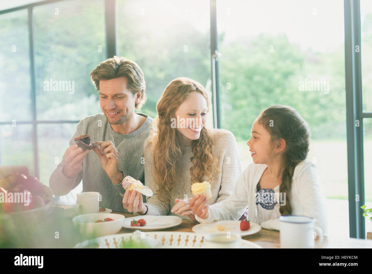 family eating cupcake table Stock Photo - Alamy