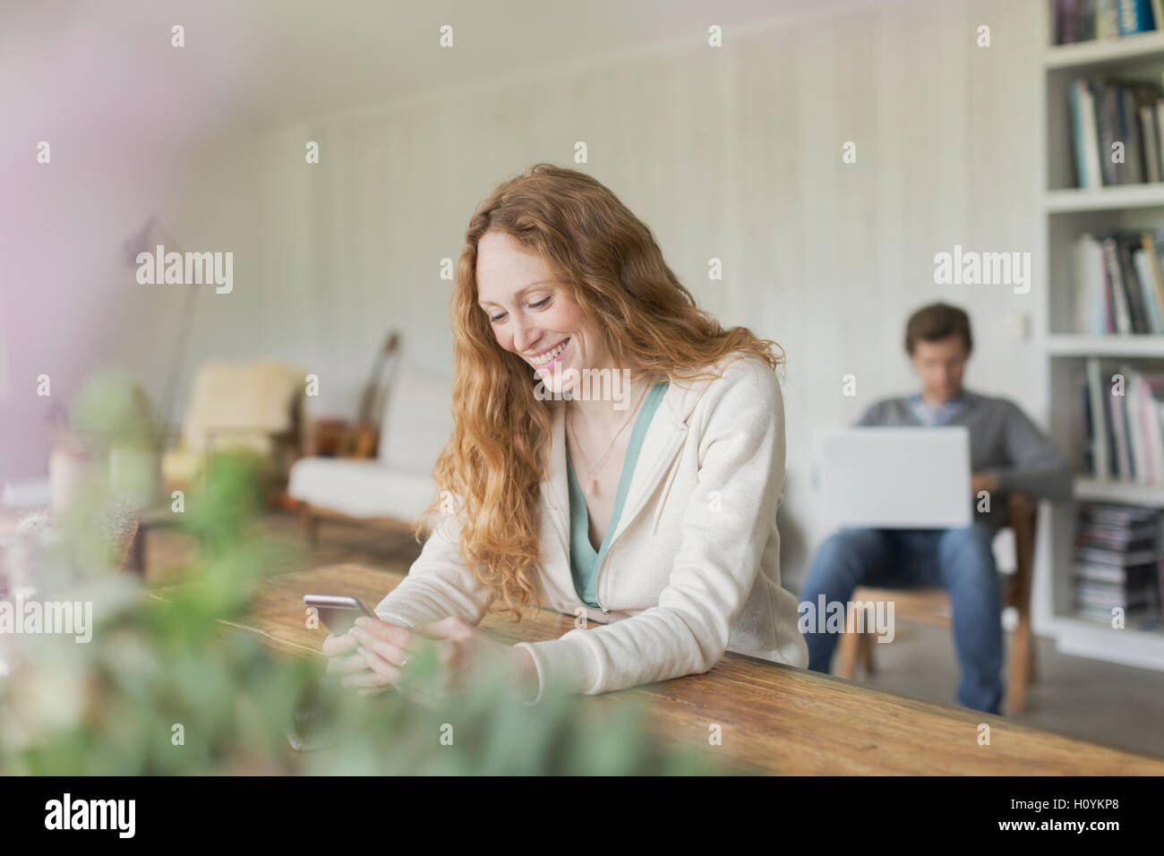 smiling woman texting cell phone dining table Stock Photo - Alamy
