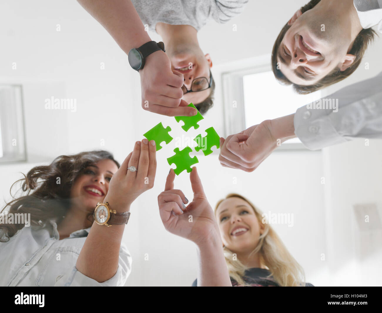 Group of business people assembling jigsaw puzzle and represent team ...