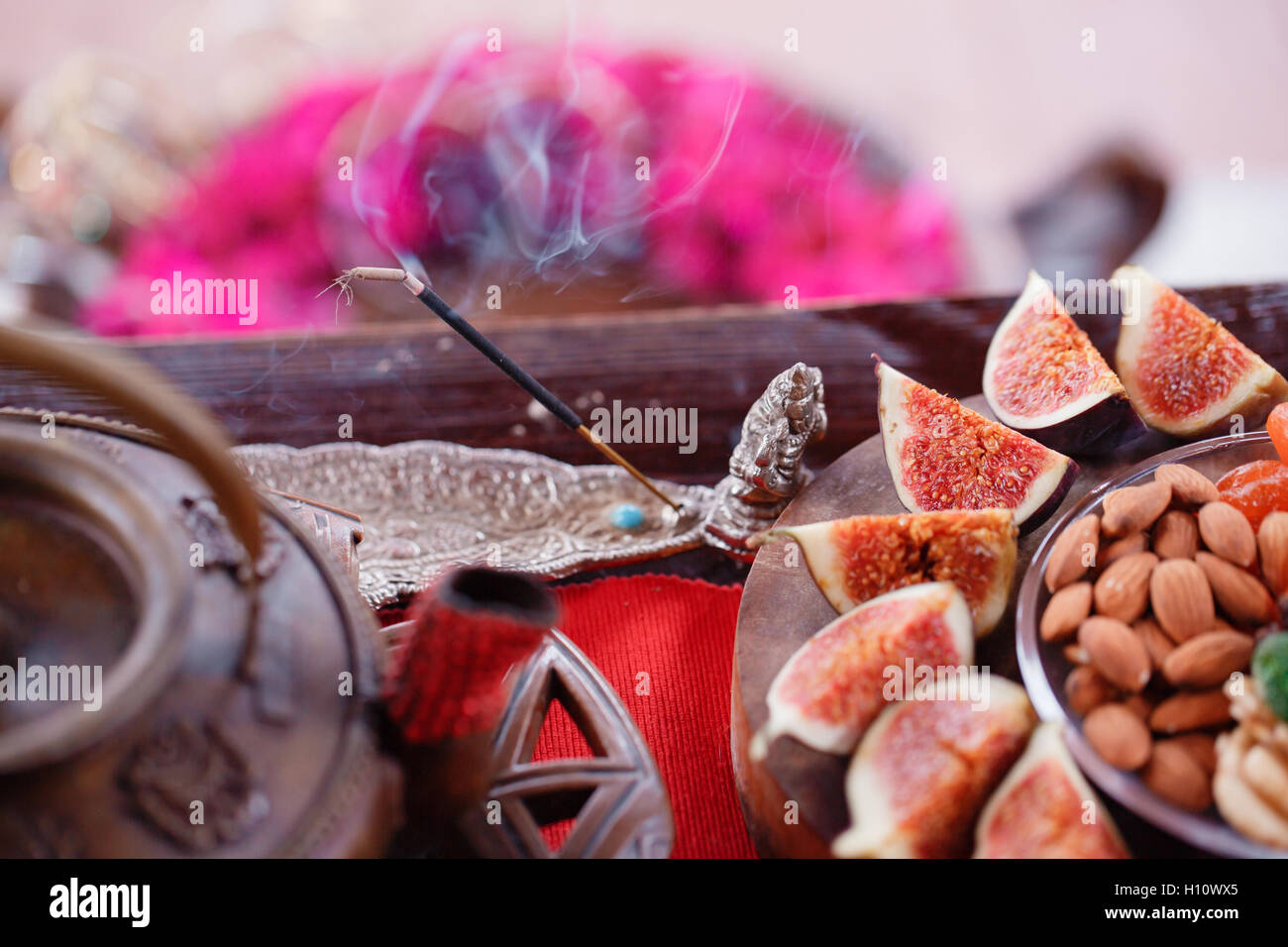 smoking incense. Indian breakfast figs and nuts on a wooden table ...