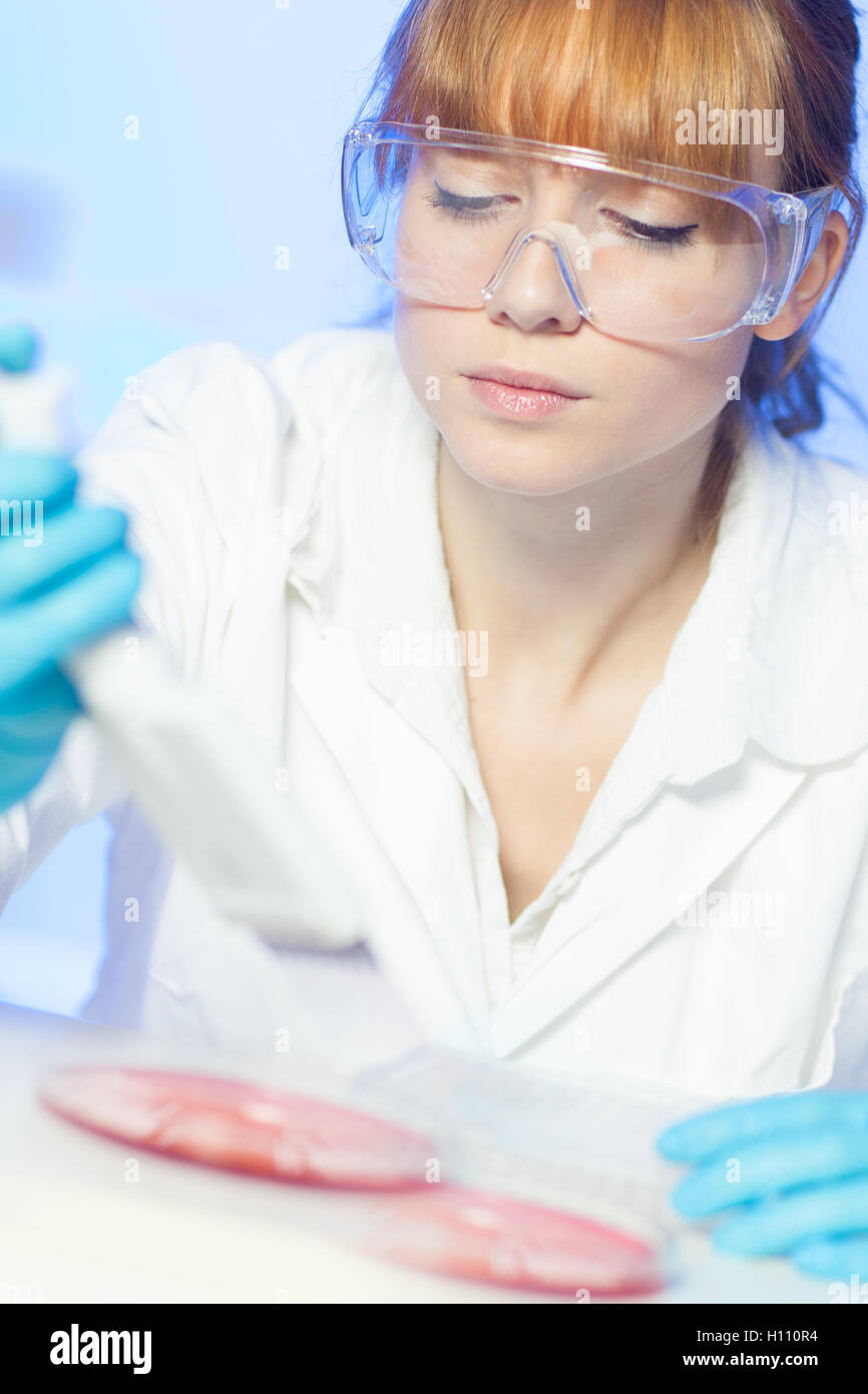 Attractive young scientist pipetting Stock Photo - Alamy
