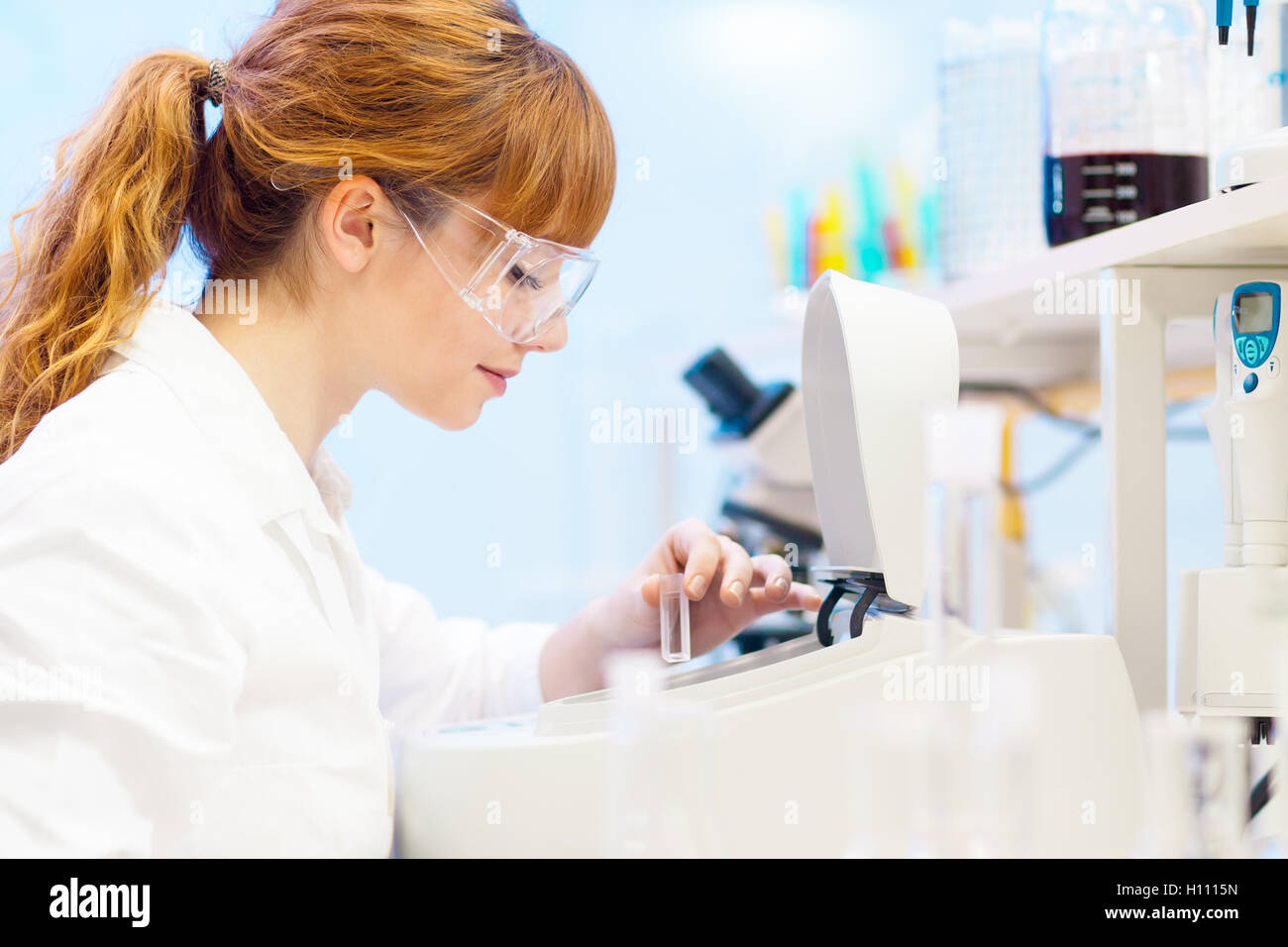 Attractive young scientist pipetting Stock Photo - Alamy