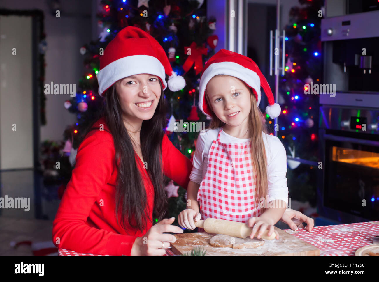 Adorable girl with her mother baking Christmas cookies in the kitchen Stock Photo - Alamy