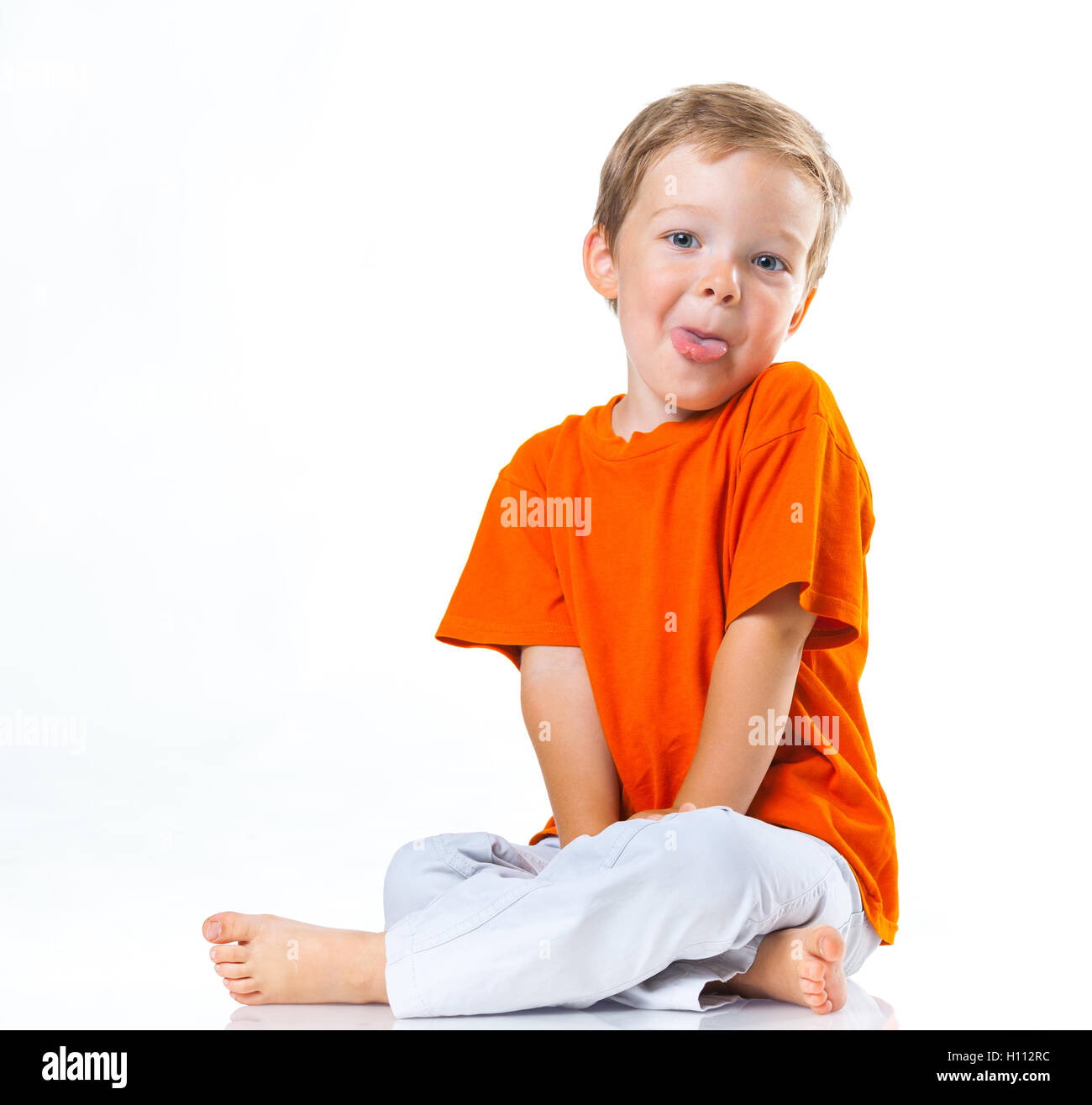 Happy boy sitting on the floor Stock Photo - Alamy