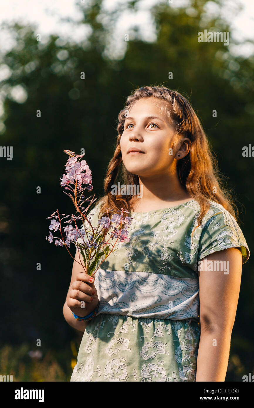 Portrait of a beautiful young teenage girl with a branch of willow in ...