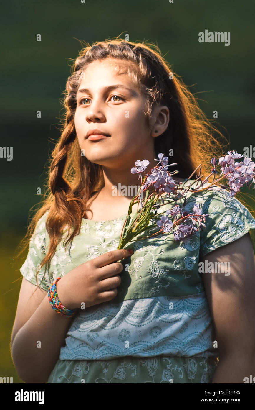Portrait of a beautiful young teenage girl with a branch of willow in ...
