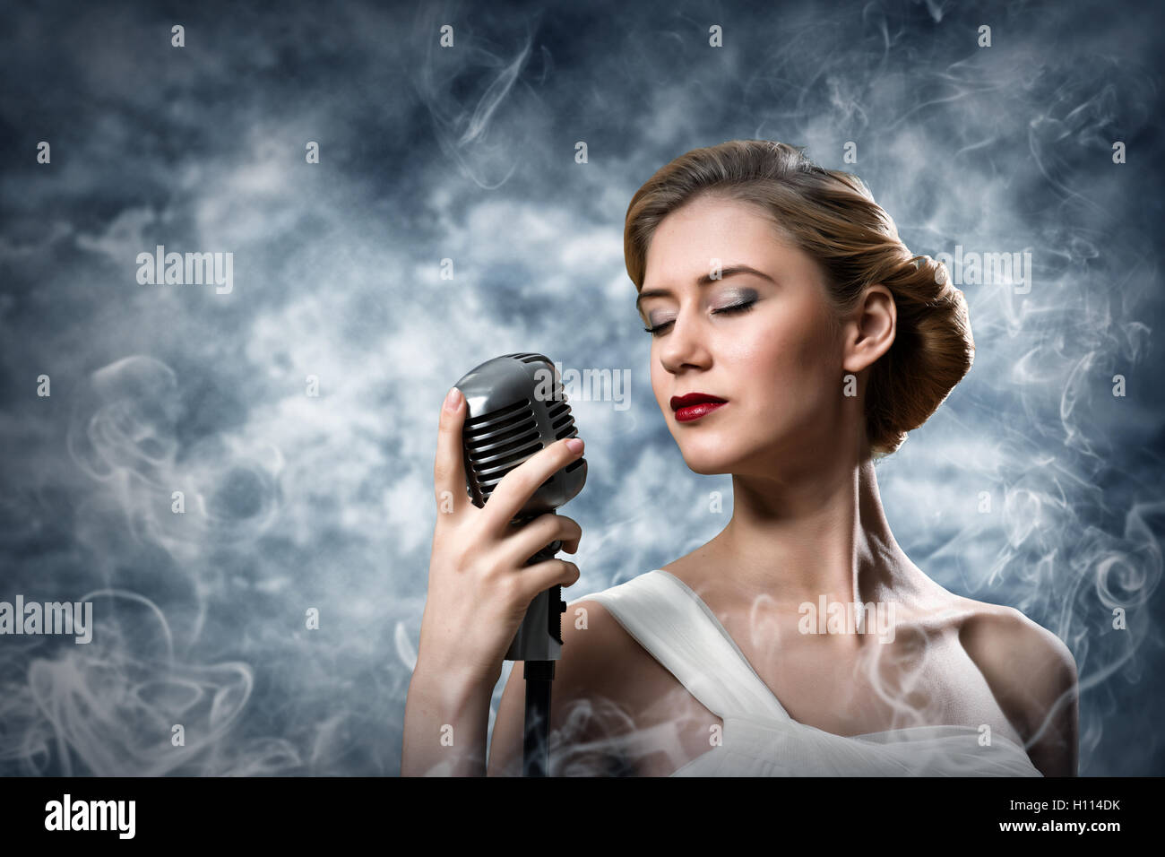 beautiful blonde woman singer with a microphone Stock Photo - Alamy