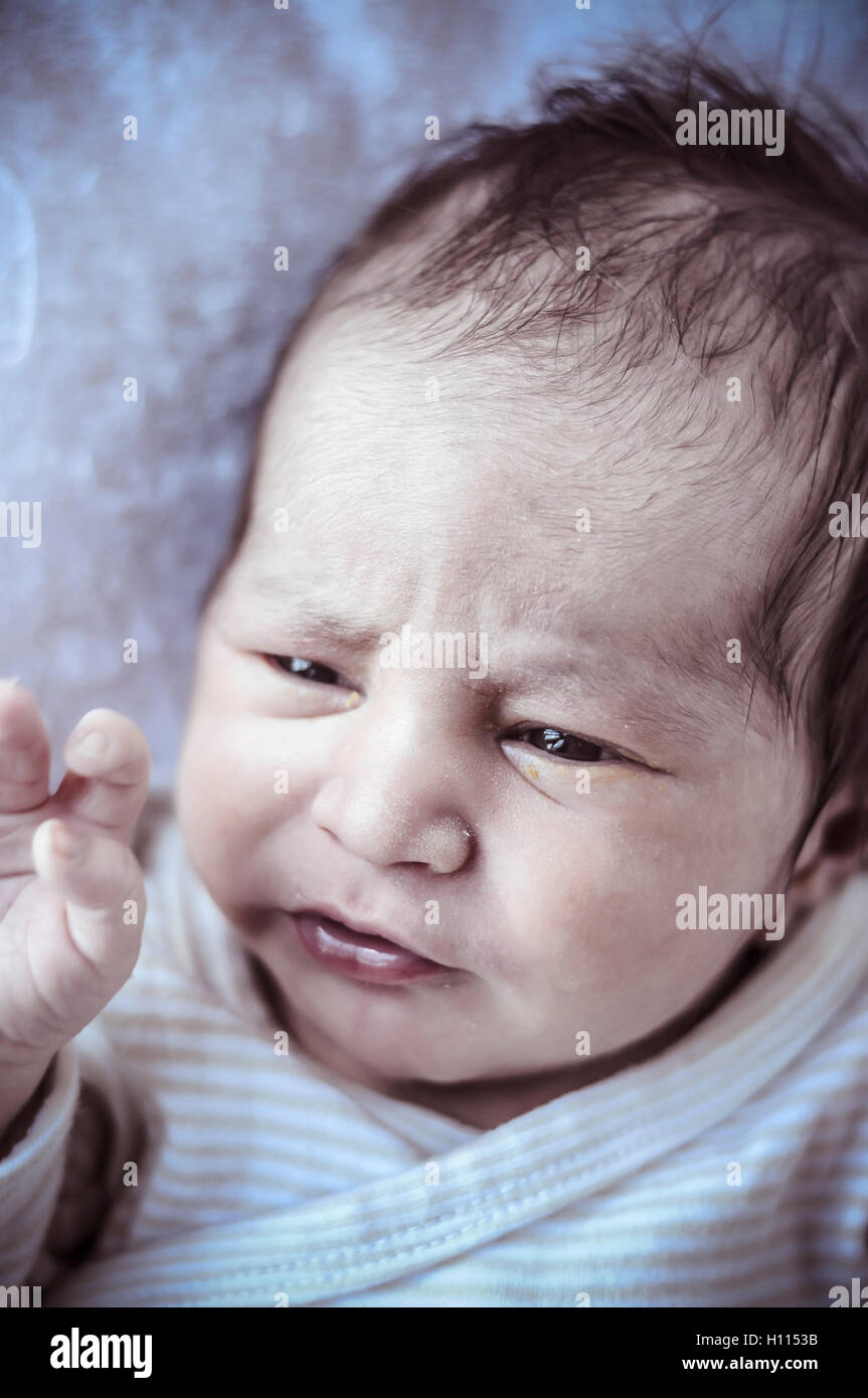 new born baby curled up sleeping on a blanket, multiple expressi Stock ...