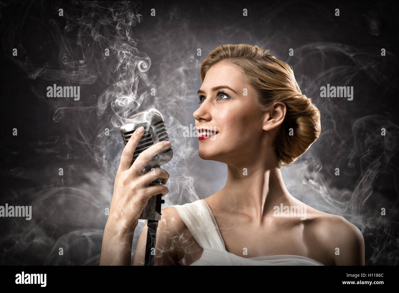 beautiful blonde woman singer with a microphone Stock Photo - Alamy