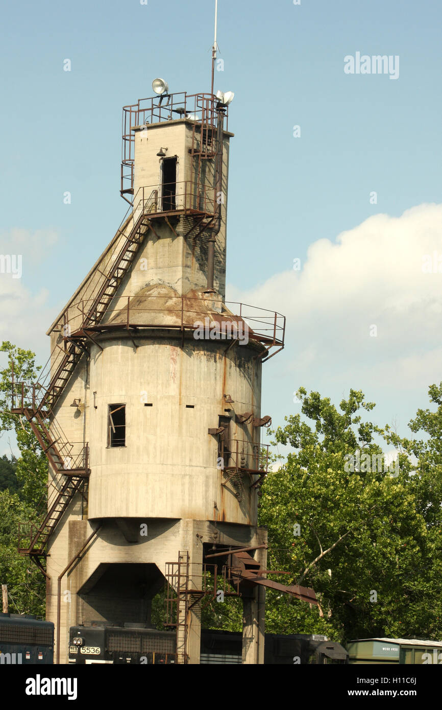 Train passing through tower at industrial complex Stock Photo - Alamy
