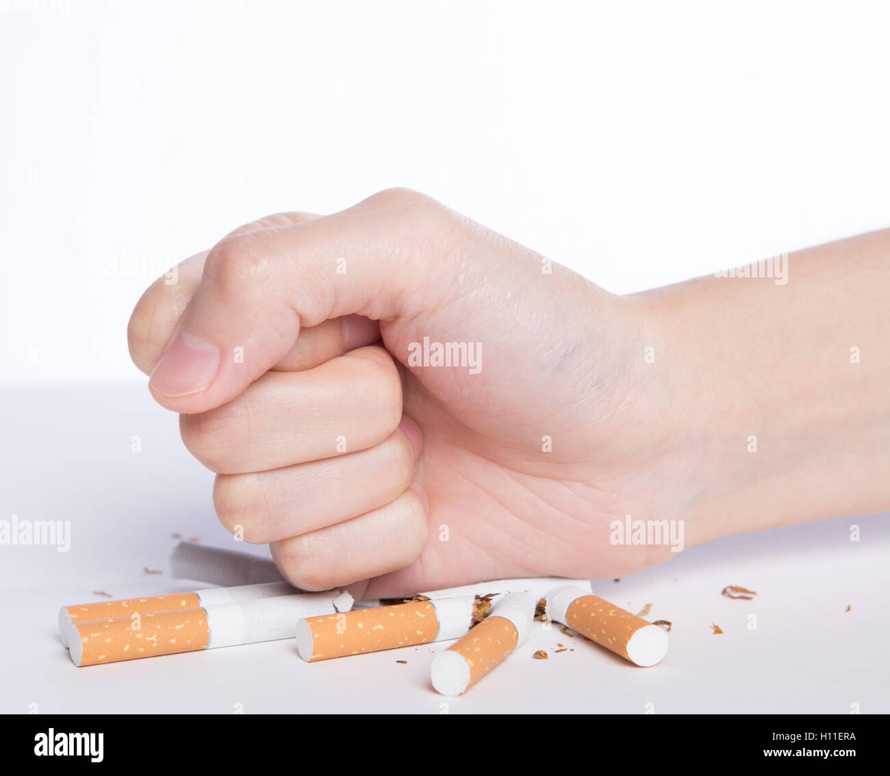 No smoking concept, closeup of clenched fist pounding cigarettes, no ...