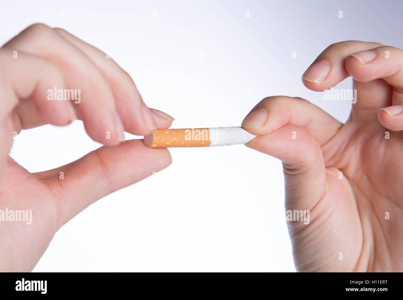 No smoking concept, closeup of hands holding cigarette, no smoking sign ...