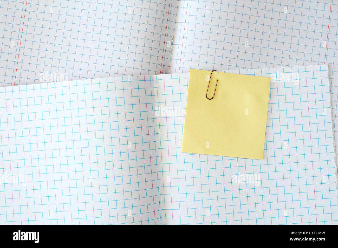 Squared exercise book with blank yellow sticky note Stock Photo - Alamy
