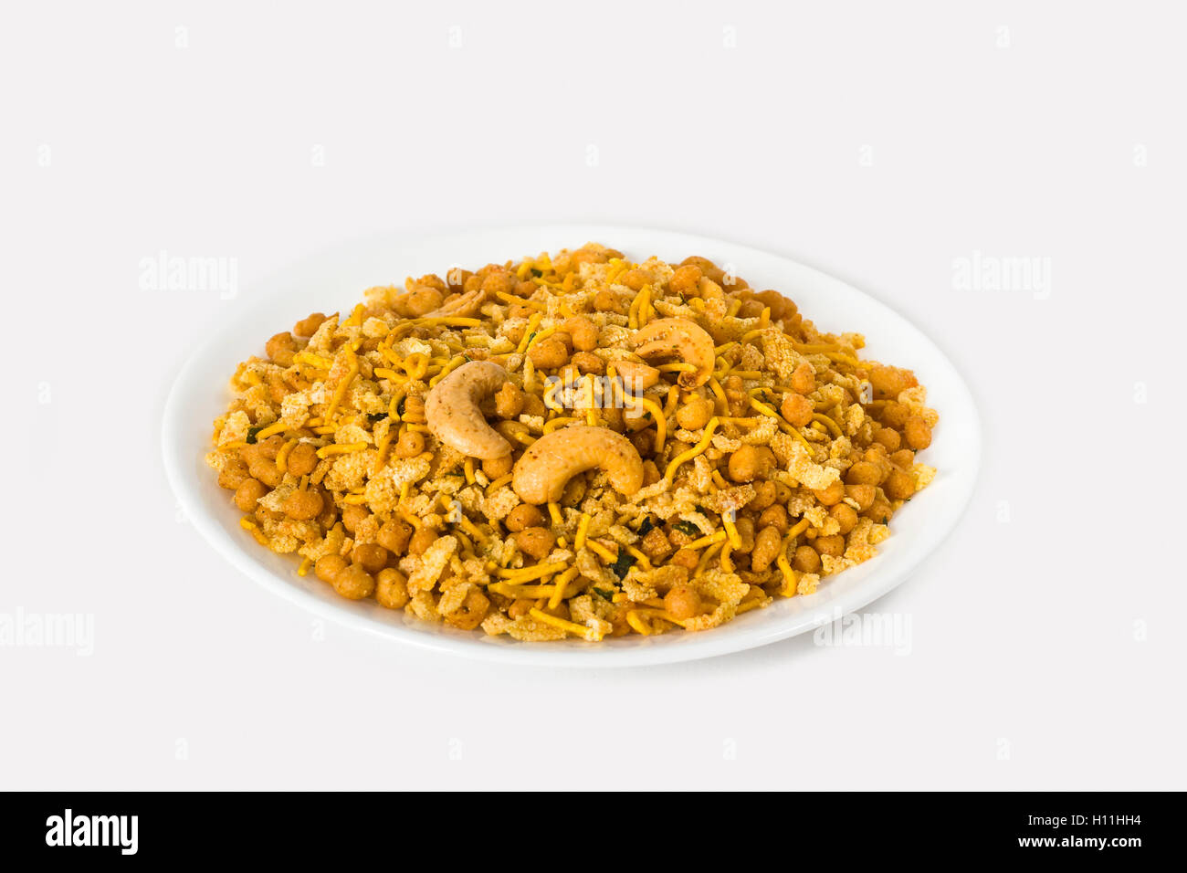 A plate of Bombay mix snack on a white background Stock Photo - Alamy