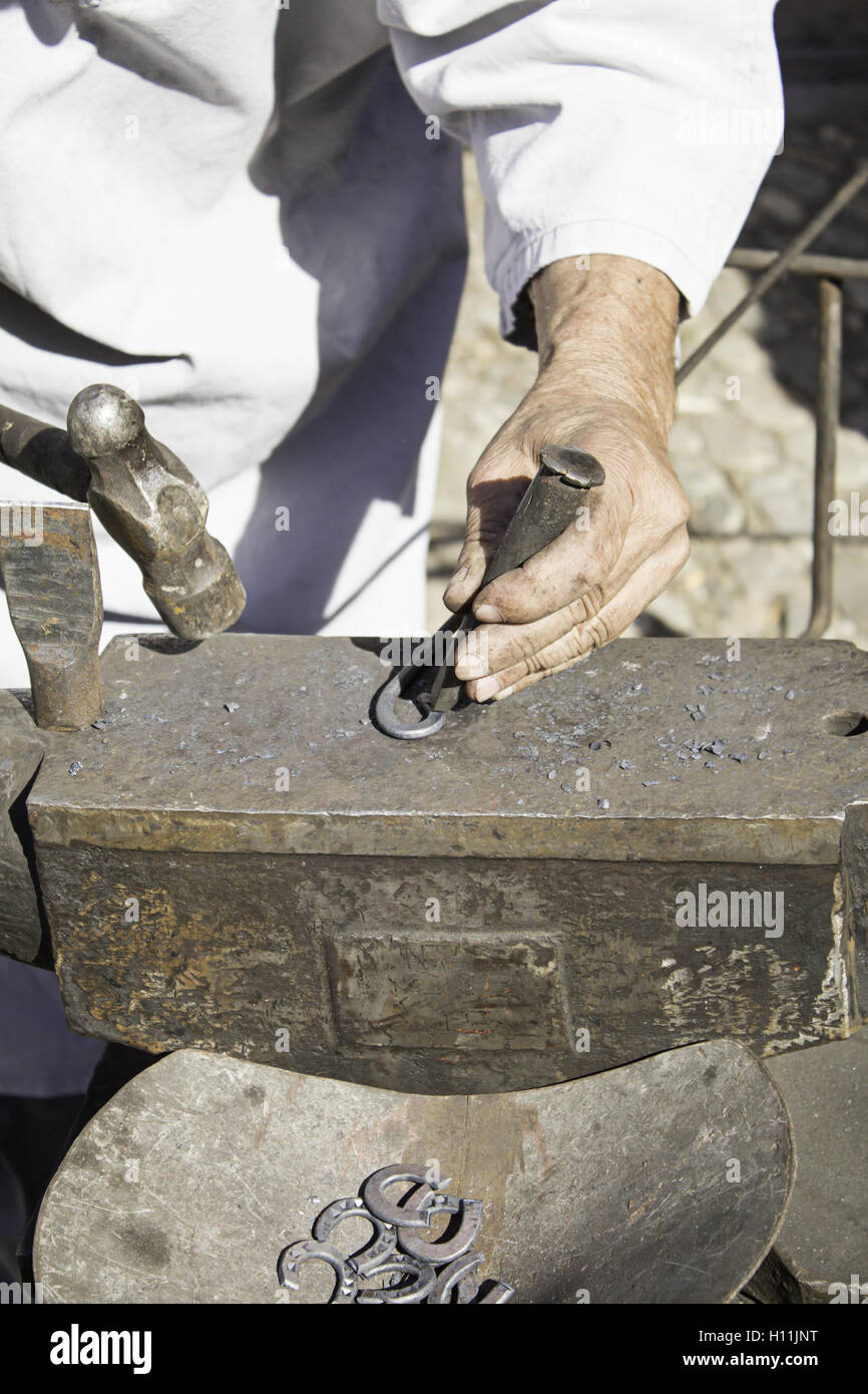 Working blacksmith making horseshoes iron industry Stock Photo - Alamy