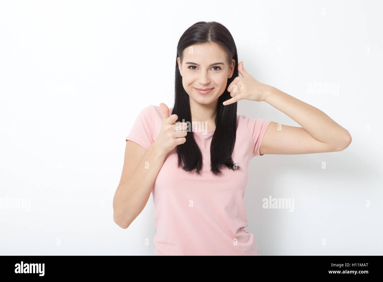 Call me. Woman showing sign and smiling on white Stock Photo - Alamy