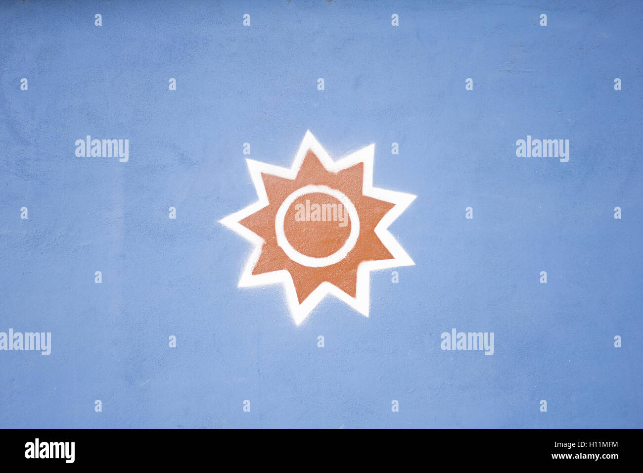 Red sun symbol drawn on the wall, while Stock Photo - Alamy
