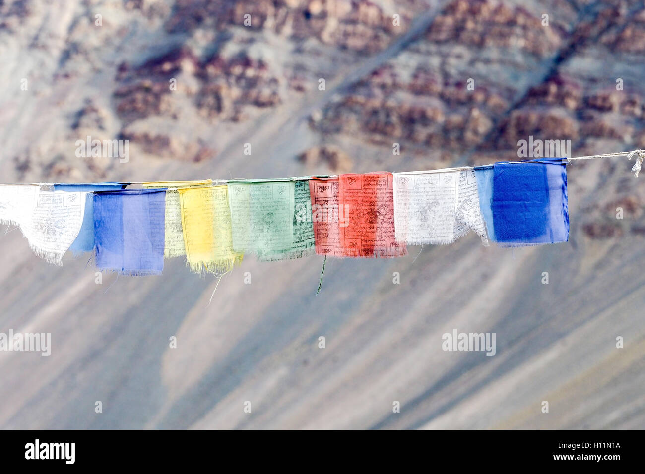 Colorful prayer flags with sun shining through one of prayer flags in ...