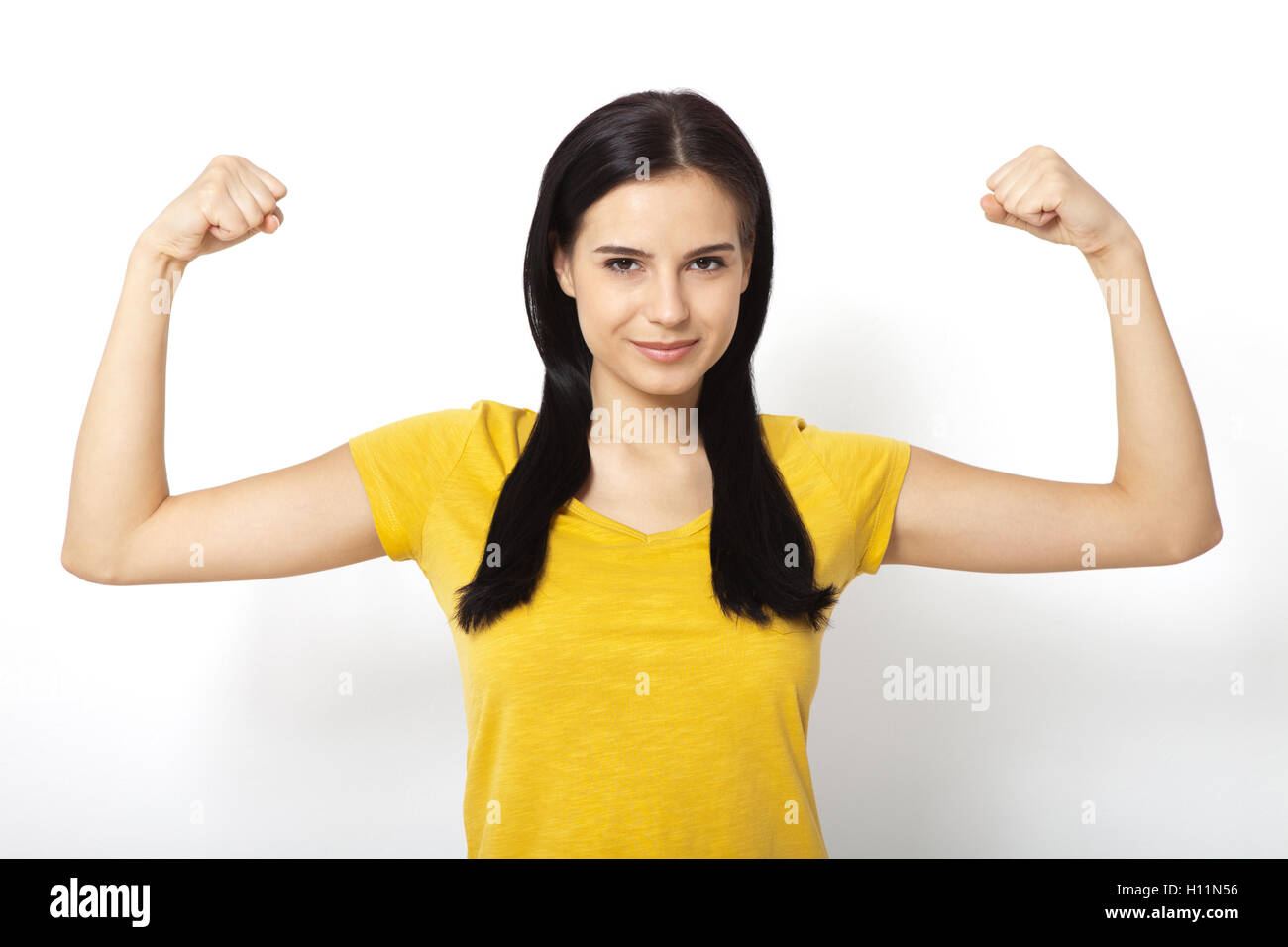 Strong woman. Beautiful girl showing her muscularity, looking at camera ...