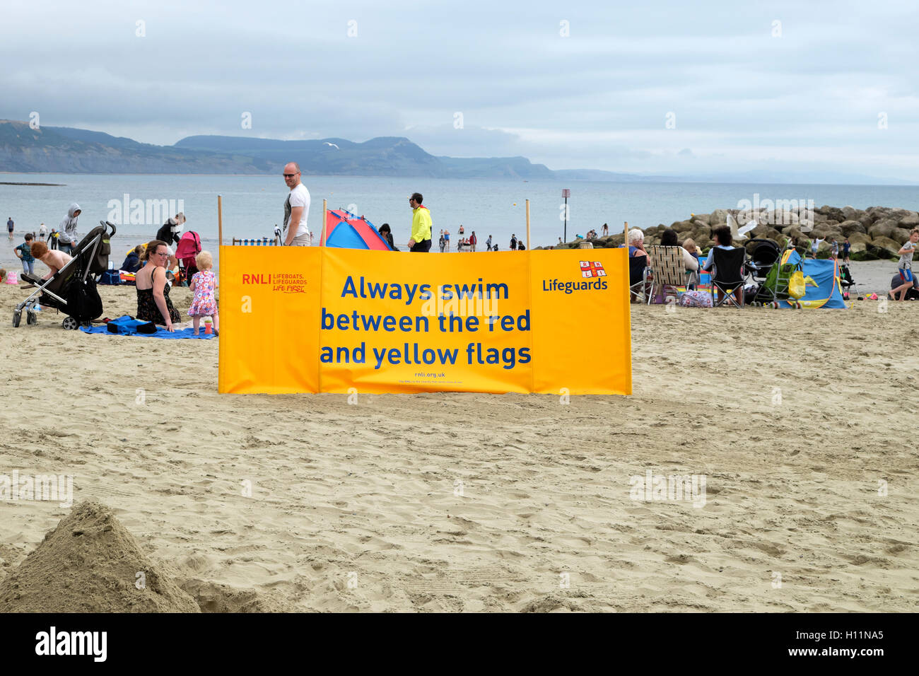 RNLI safety banner on the beach in summer at Lyme Regis, Dorset ...