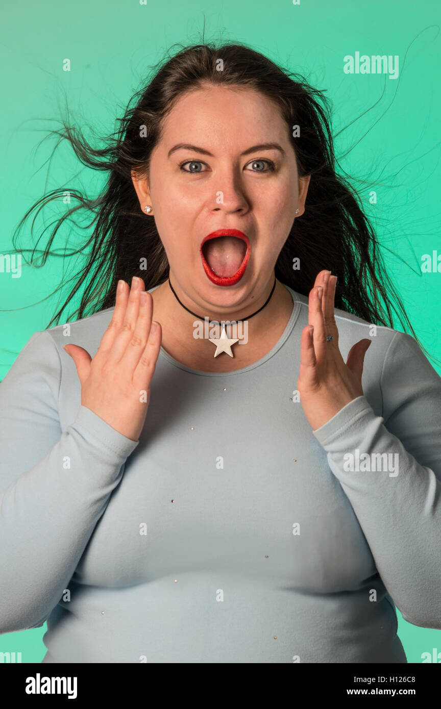 Young woman studio portrait looking surprised Stock Photo - Alamy