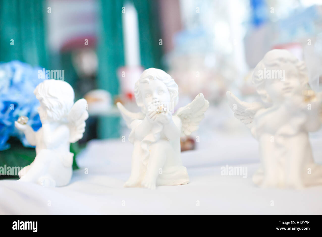 Three statues of angels on the table Stock Photo - Alamy