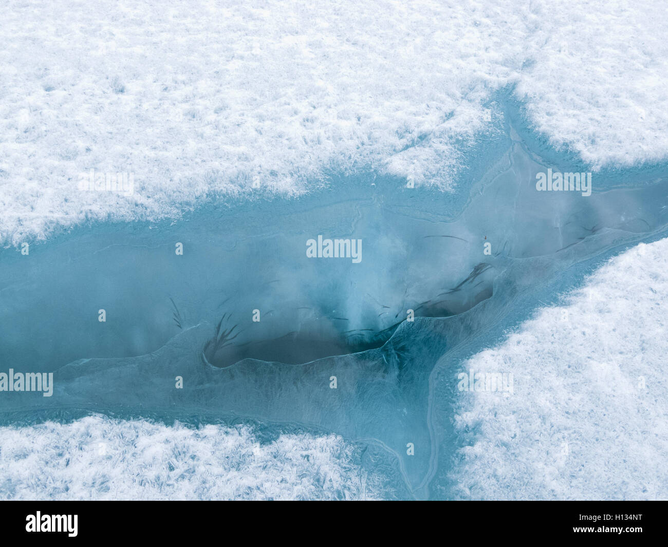 Cracked lake ice sheet nature background pattern Stock Photo - Alamy