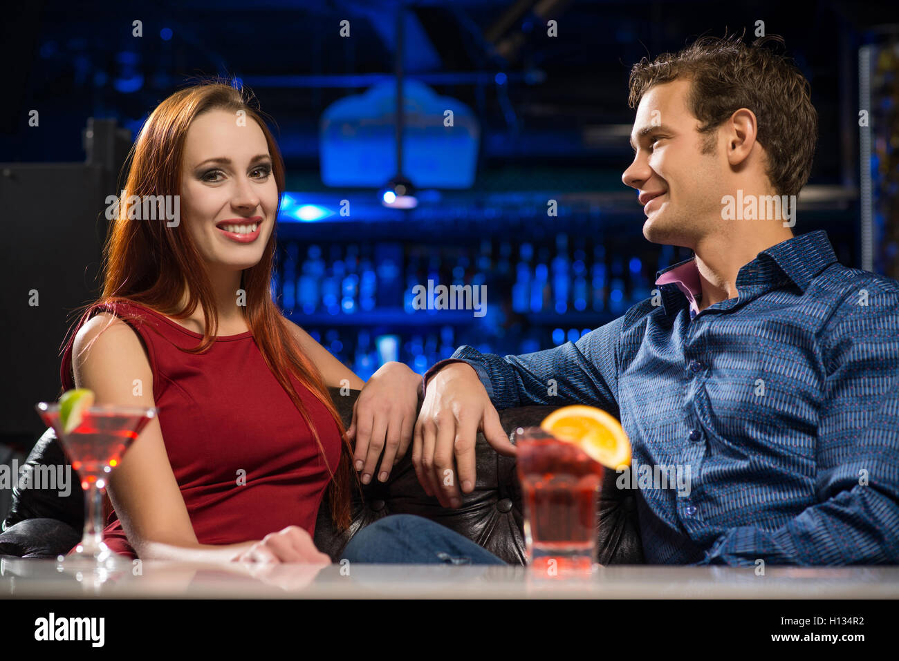 Young couple talking in a nightclub Stock Photo - Alamy